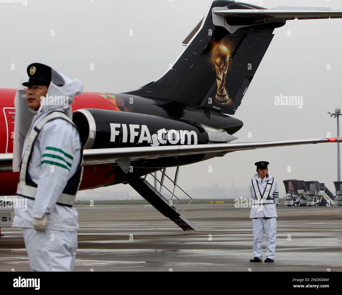 Airport security guards stand near the airplane carrying the FIFA World ...