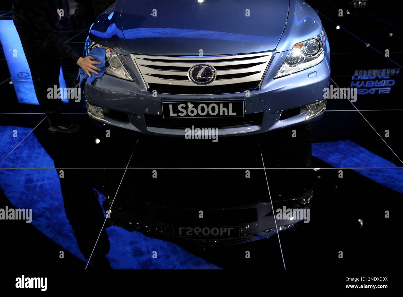 A cleaner wipes a Lexus LS 600hL on display at the booth of Toyota Motor Corp. during the China ...