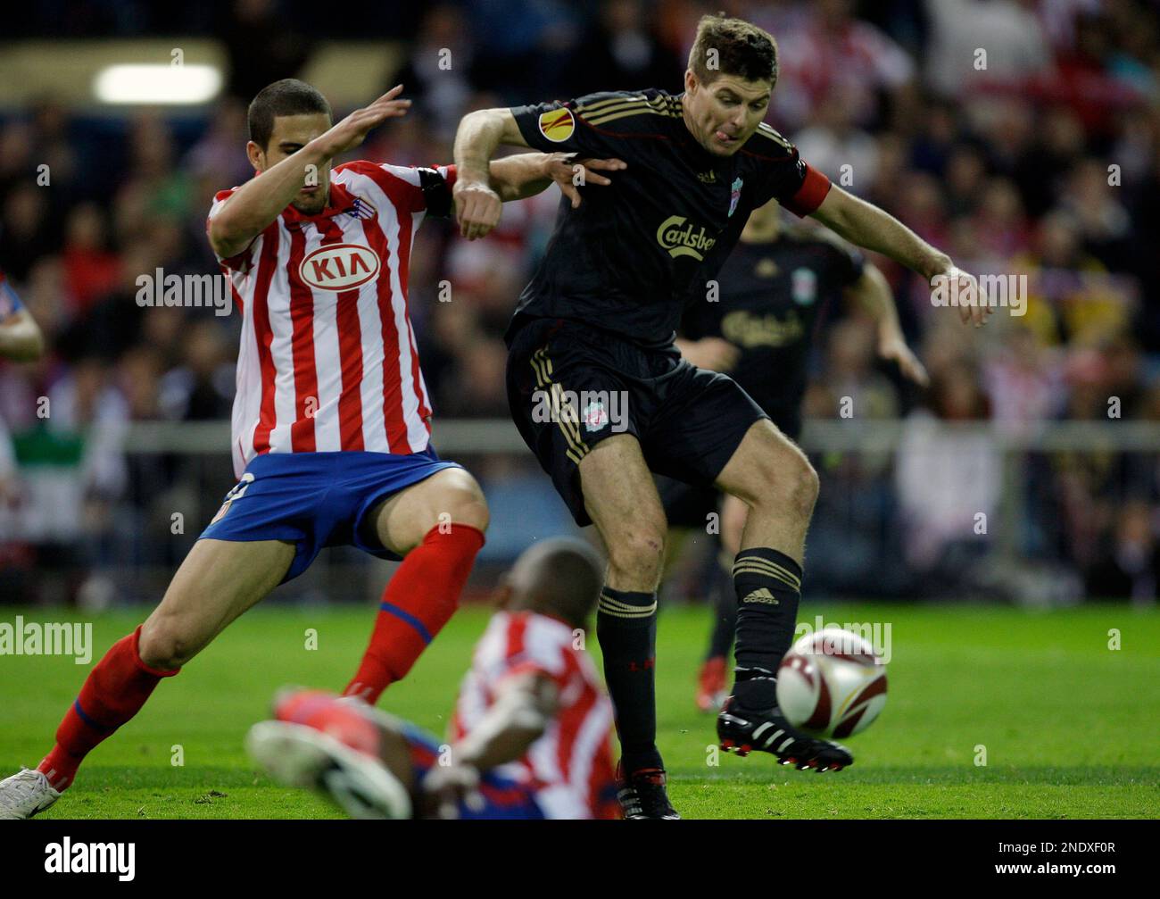 Liverpool's Steven Gerrard, right is challenged by Atletico de Madrid's ...