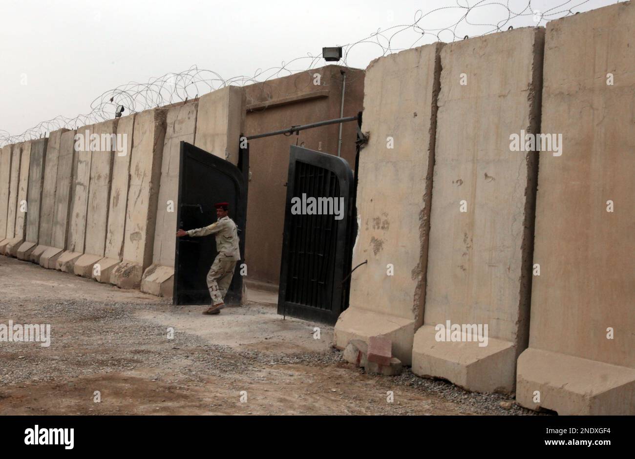 An Iraqi soldier closes the front gate to an Iraqi-run prison in ...