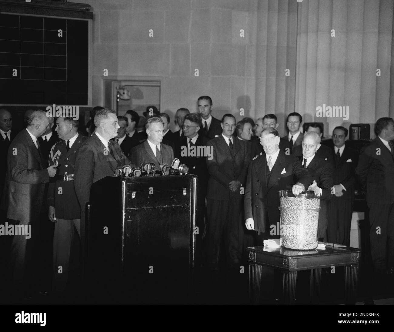 Secretary of navy Frank Knox (blindfolded) draws the fourth number—6620 ...