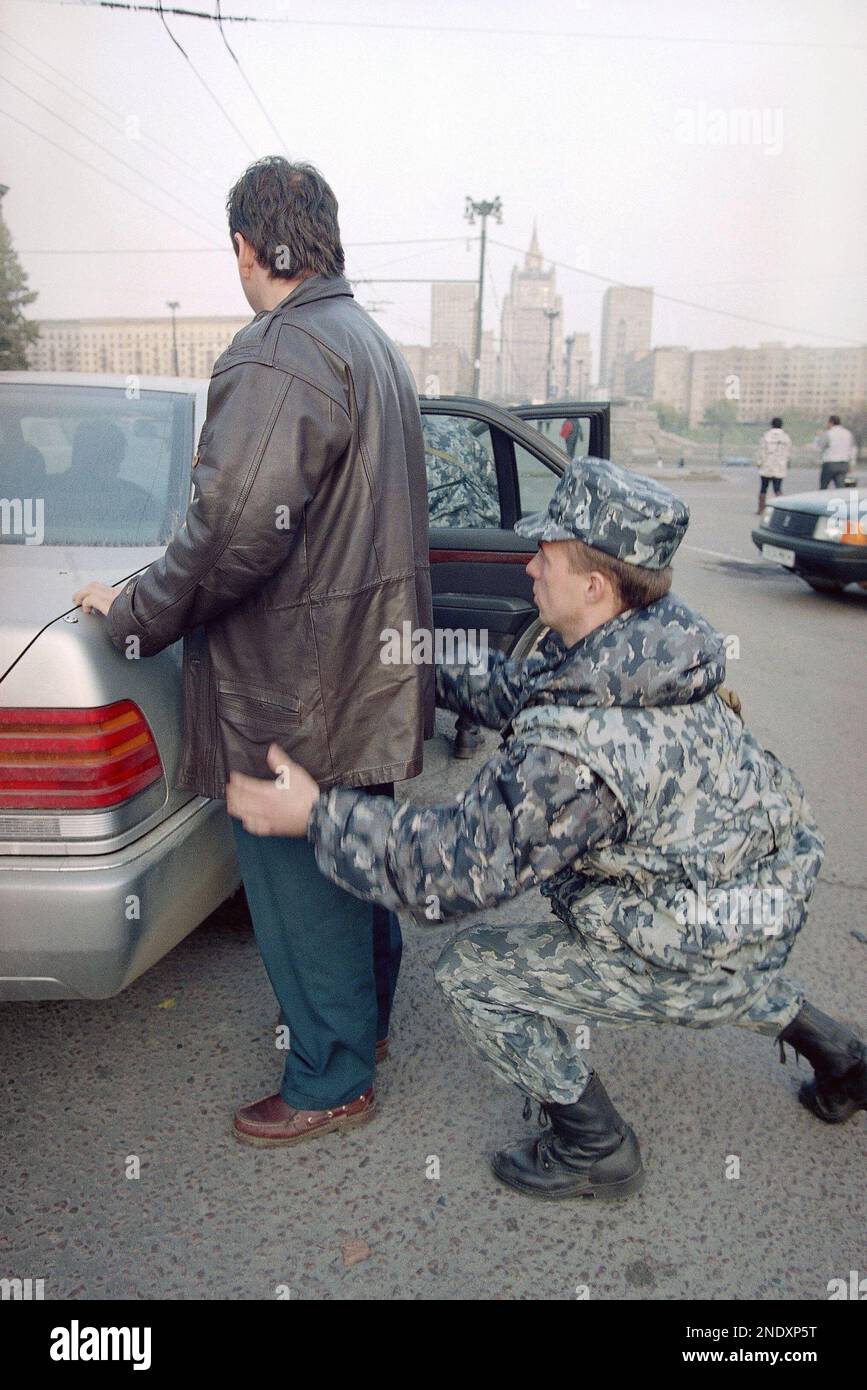 A Russian army soldier frisks a motorist at a check point in downtown ...