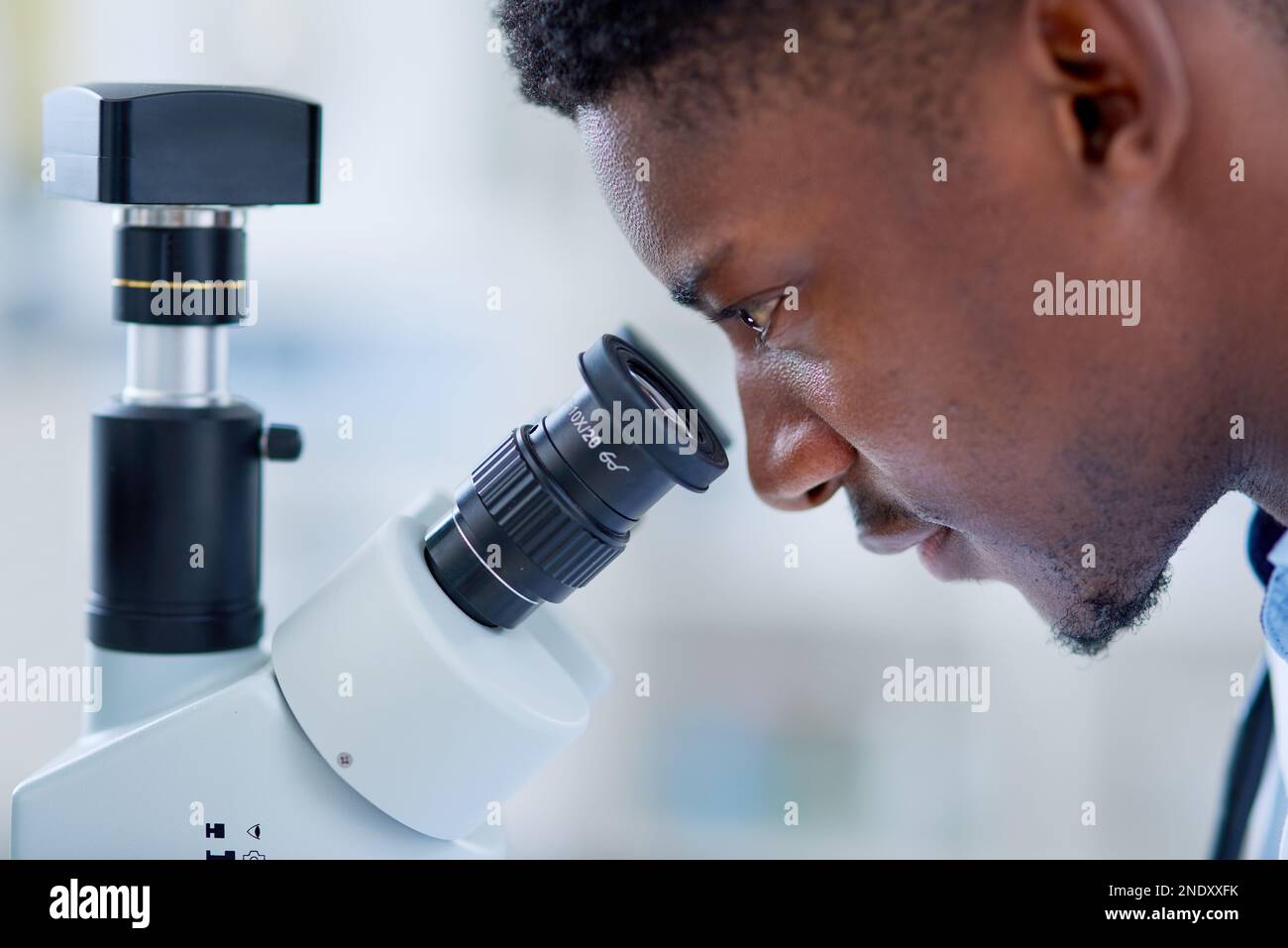 Looking through the eyes of the lens. a focused young male scientist ...