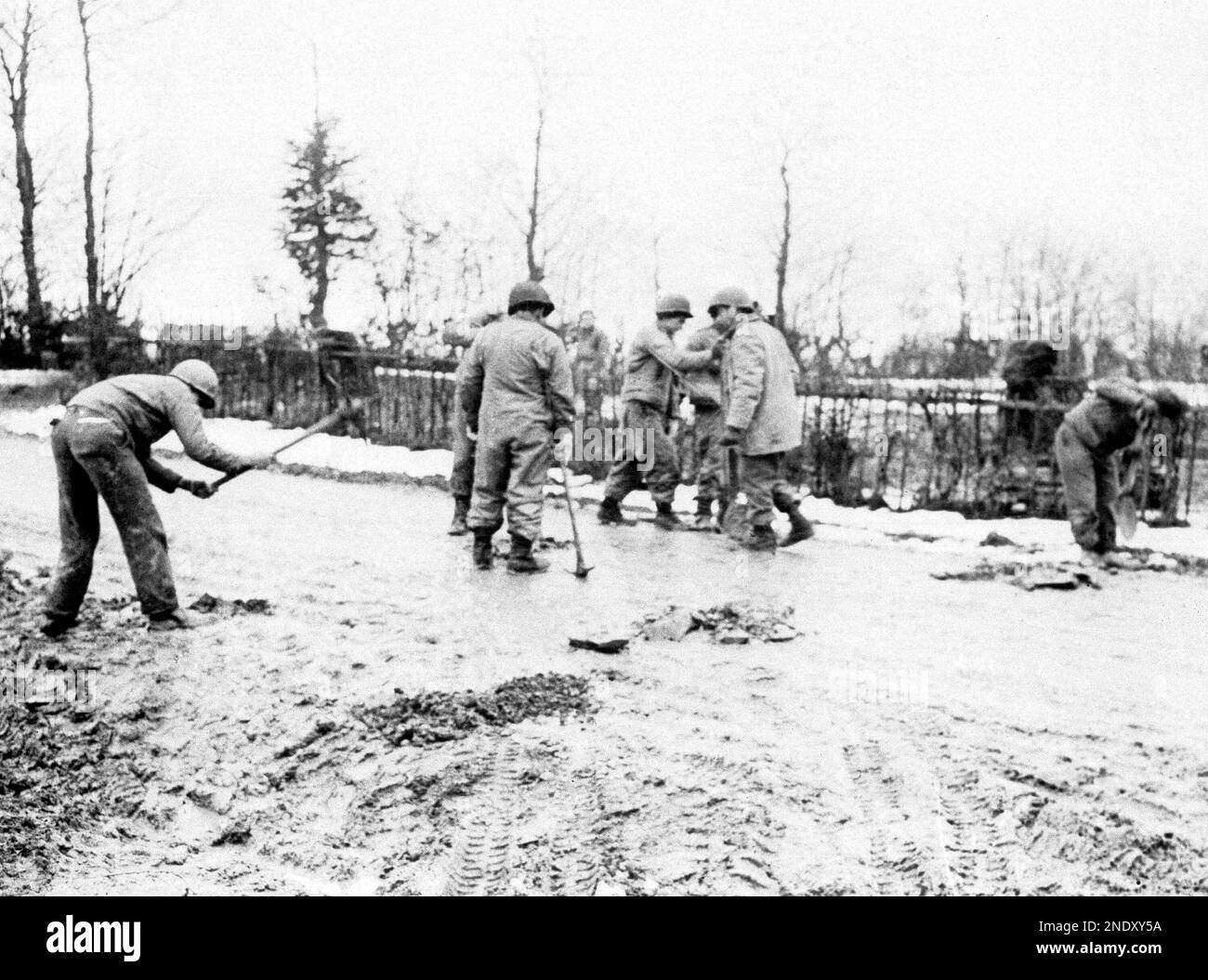 Members of an American mine-laying crew dig holes to conceal mines ...