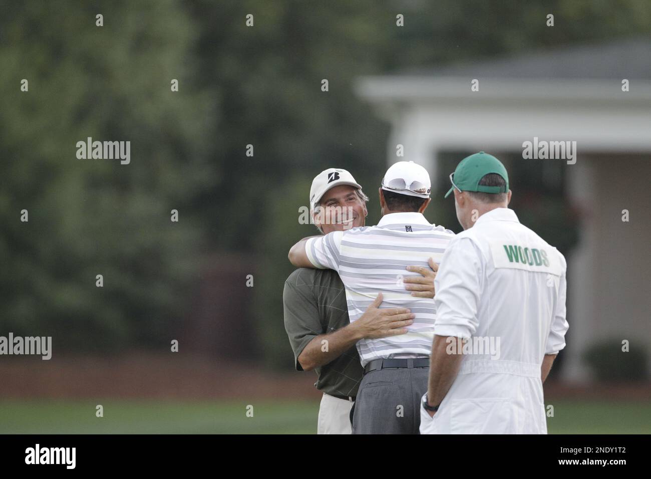 Caddy Steve Williams watches as Fred Couples, left, hugs Tiger Woods ...