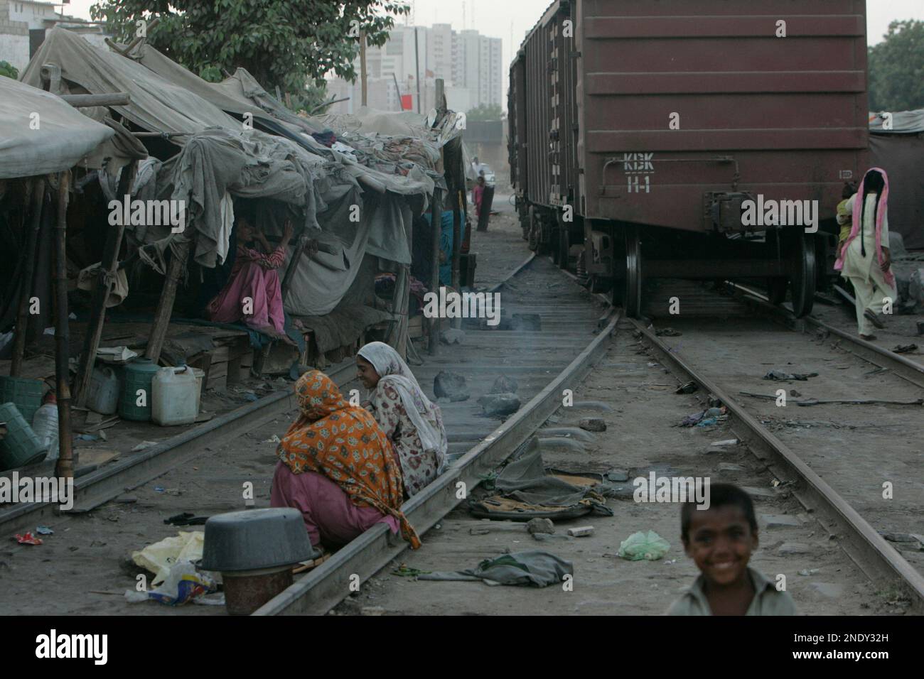 Poor Pakistani families live along a railway track in Karachi, Pakistan ...