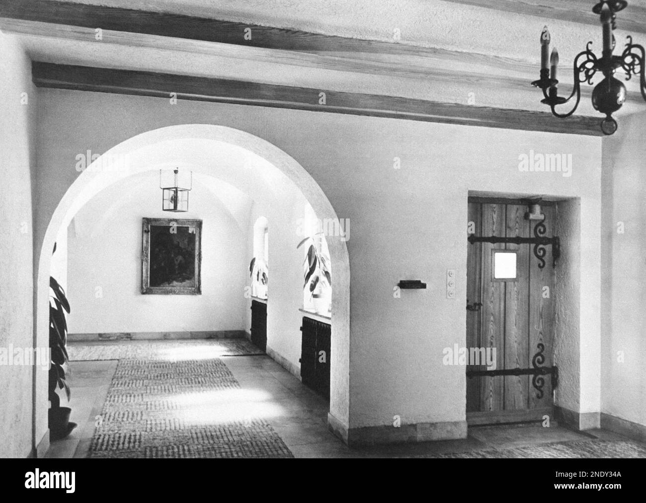 Through this heavy oak door and up this sunny hallway with its potted ...