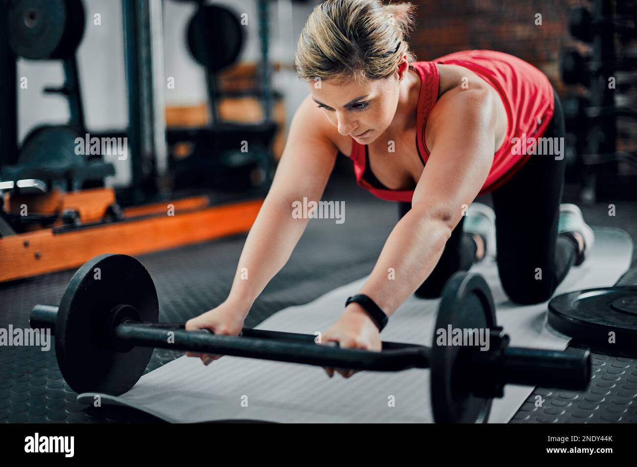 Each rep gets her closer to her goal. Full length shot of an attractive young female athlete ...