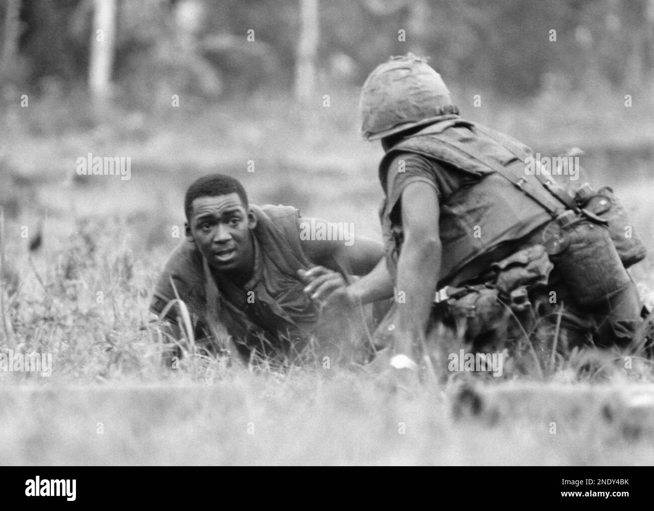 Wounded marine, trapped in open field under fire from North Vietnamese infantry, looks up to ...