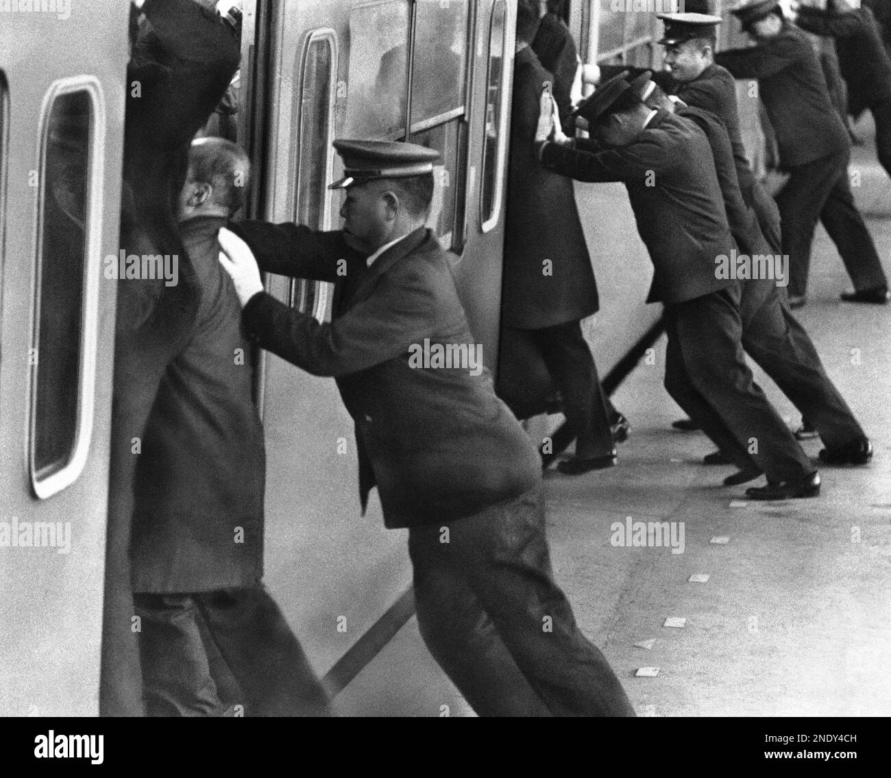 Japanese "pushers" work in a subway station shoving passengers into ...