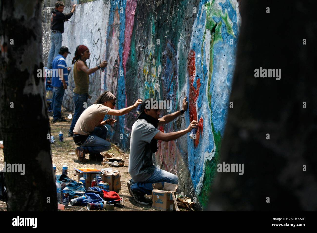 Graffiti artists work on graffiti on a wall of the Azteca stadium in ...