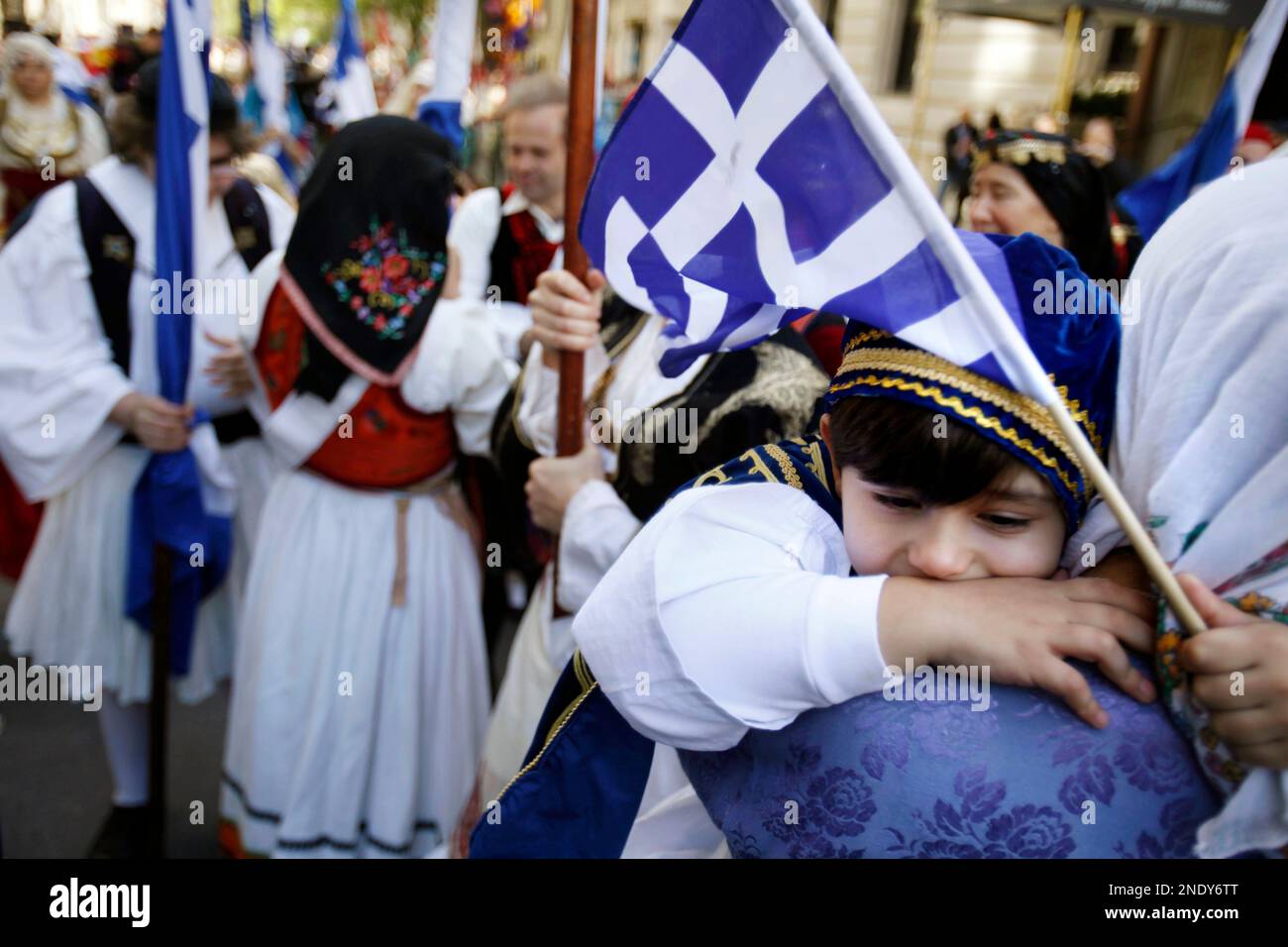 Alexander Skevas, 4, takes shelter from the wind in his mother's ...