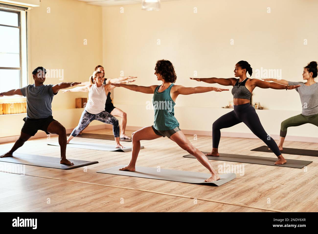 An army of yoga warriors. a group of young men and women practicing the ...