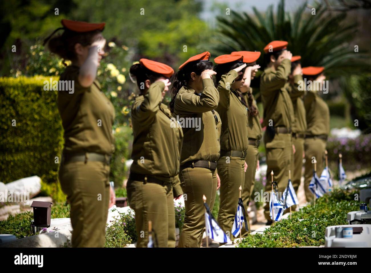 Israeli soldiers salute after placing Israeli flags on graves of fallen ...