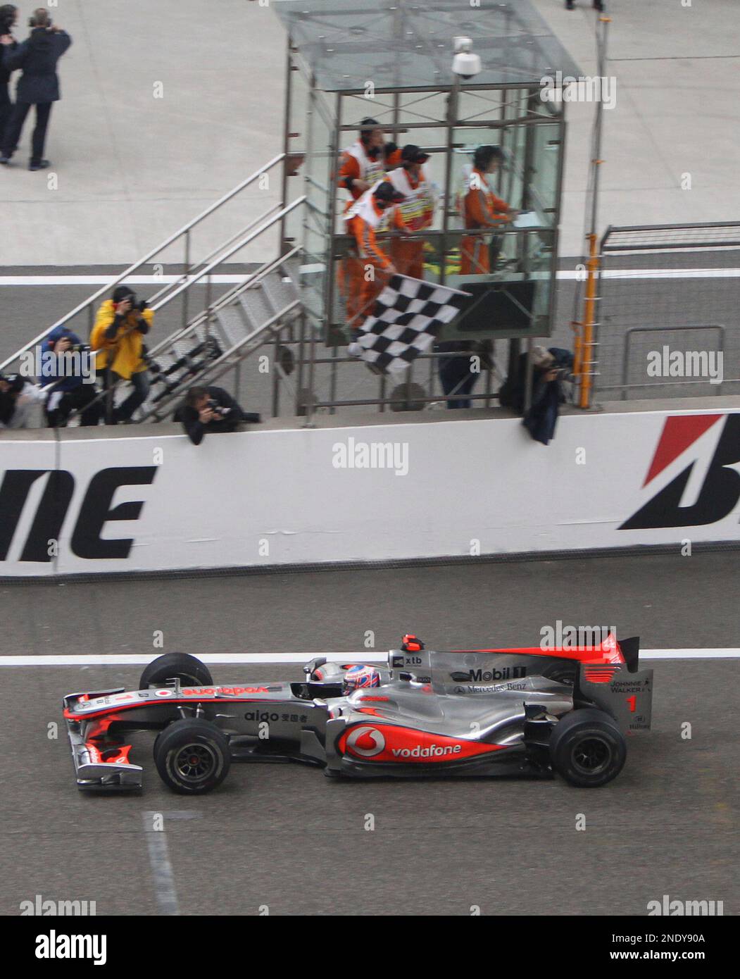 McLaren Formula One driver Jenson Button of Britain crosses the finish ...