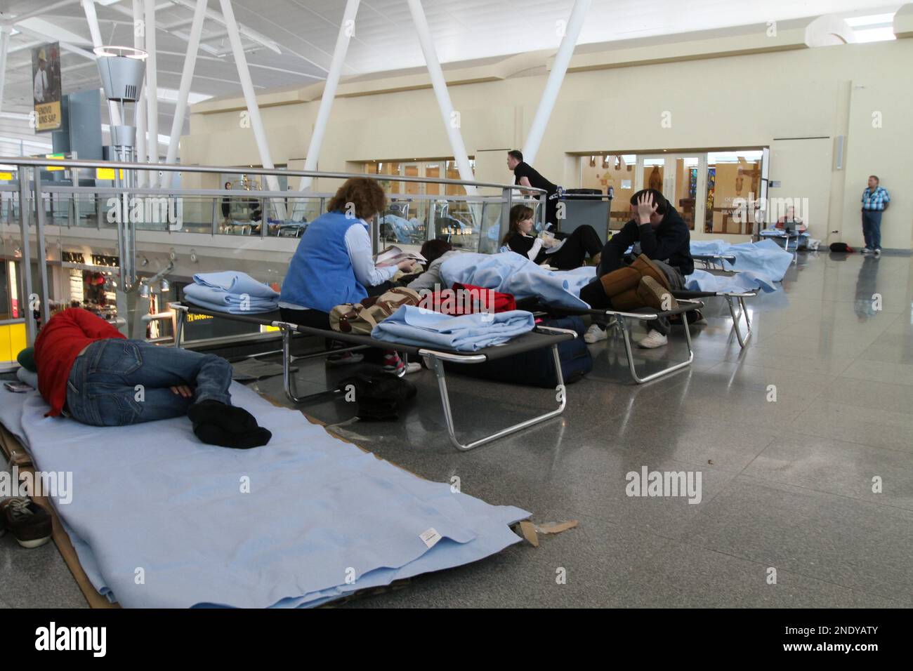 People rest on cots as they wait in Terminal 4 at JFK International ...