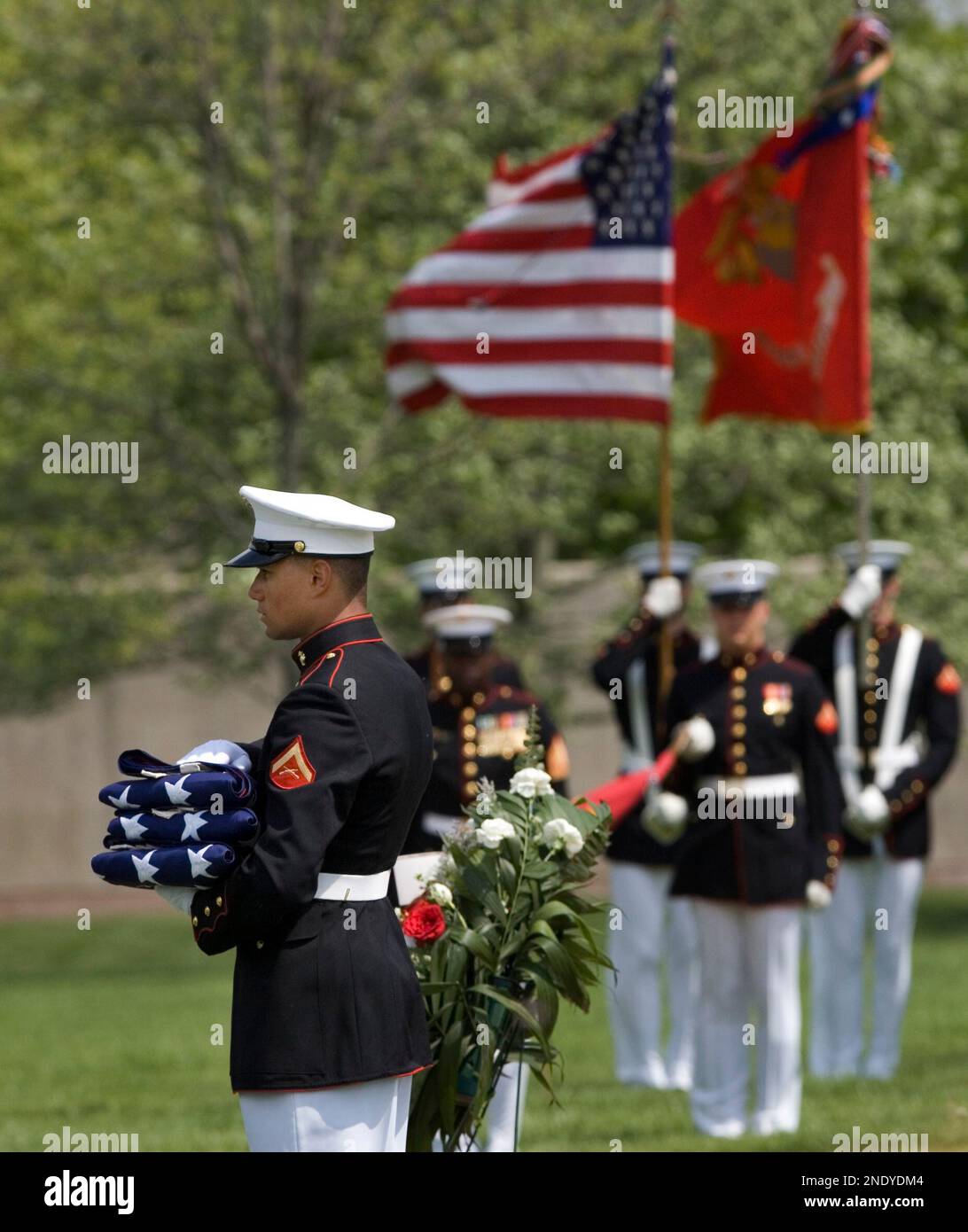 A Marine honor guard holds American flags to be handed to relatives of ...