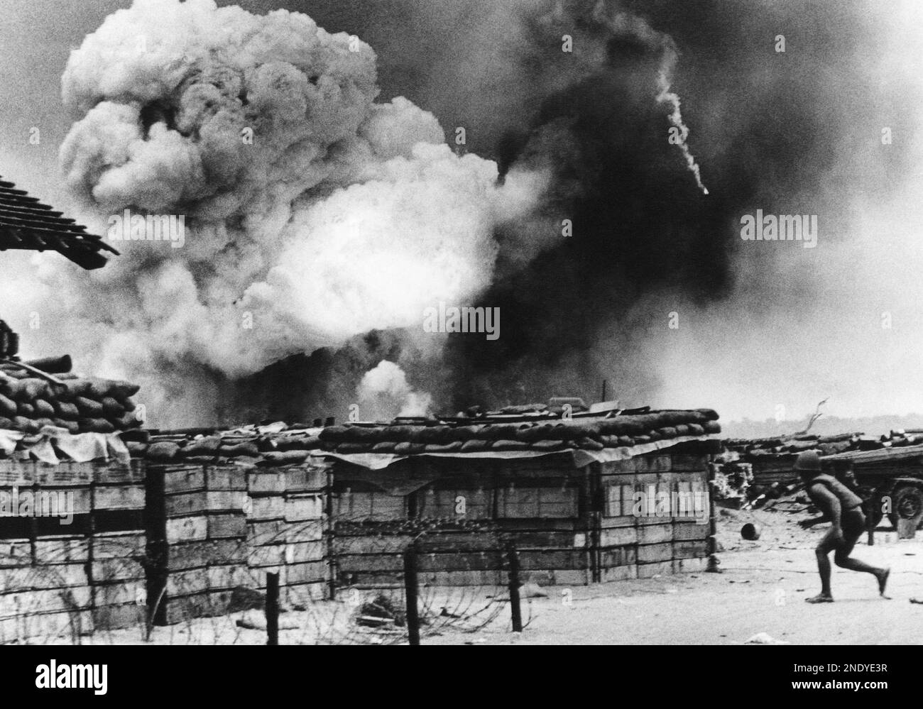 A South Vietnamese soldier dashes for cover as an ammunition dump at a ...