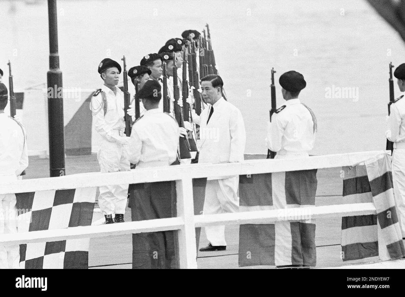 President Ngo Dinh Diem of South Vietnam, center, walk through saluting ...