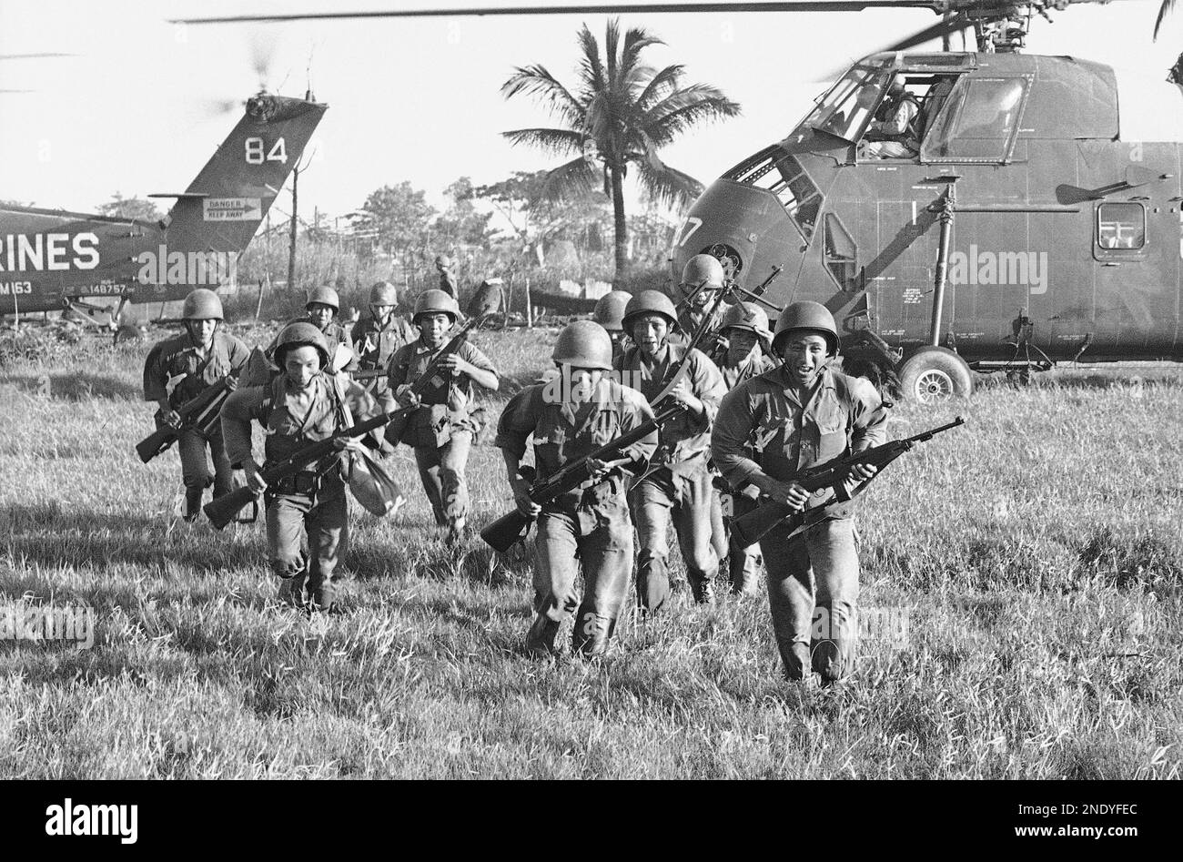 South Viet Nam troops rush toward camera and embarkation by one of group of waiting helicopters ...