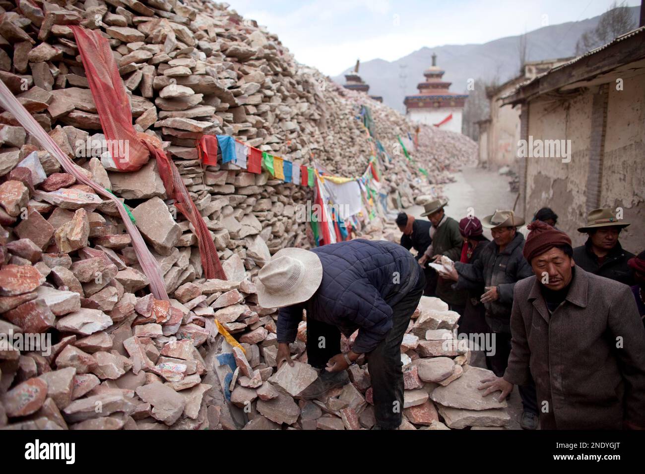 People move stones in search for a woman buried in a pile of collapsed ...