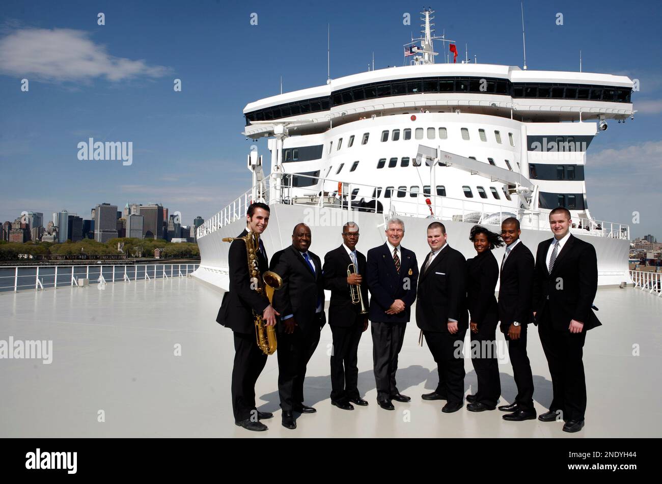 Queen Mary 2 Entertainment Director Ray Rouse, center, poses with ...