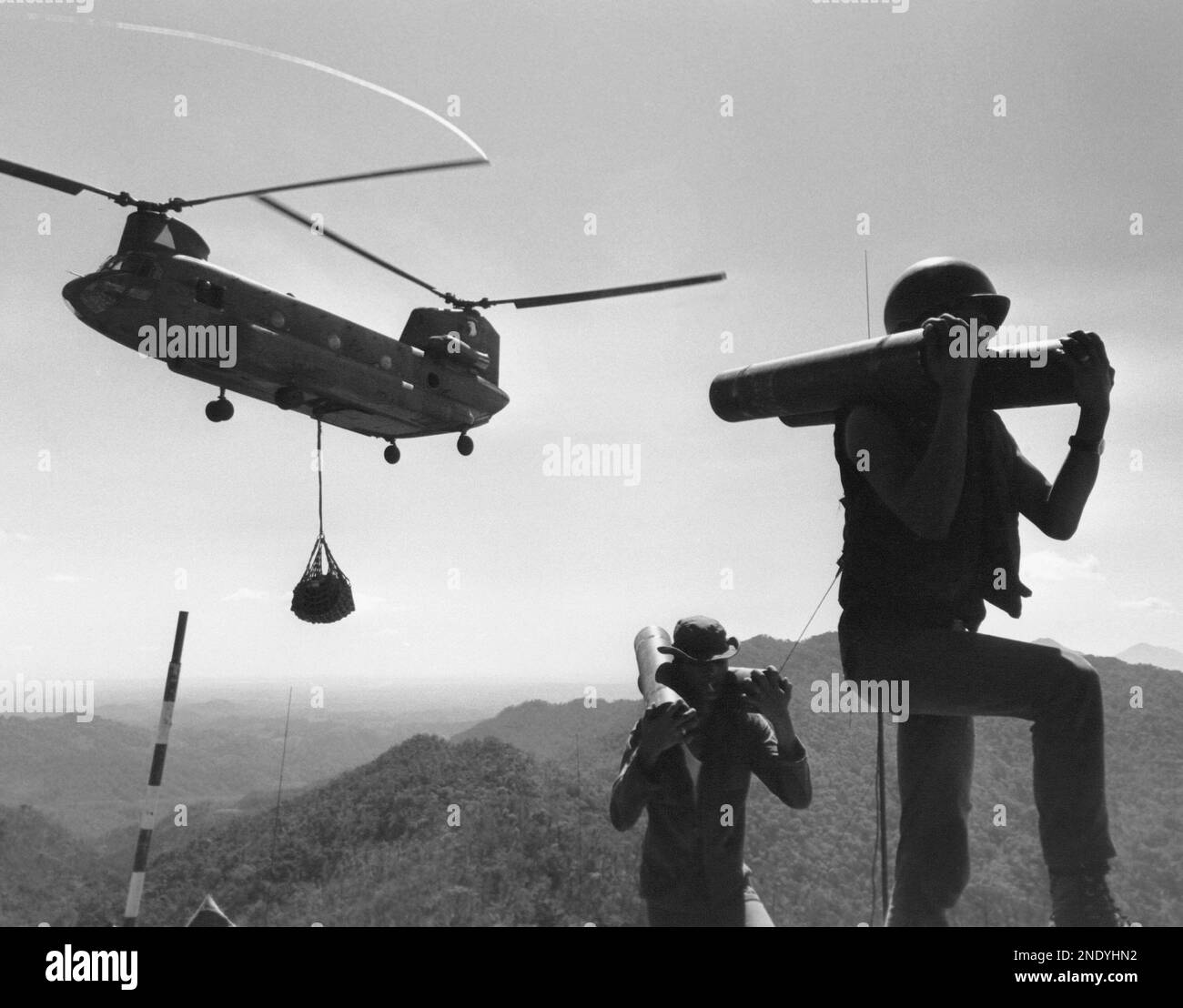 Two South Vietnamese soldiers carry artillery rounds to firing pits at ...
