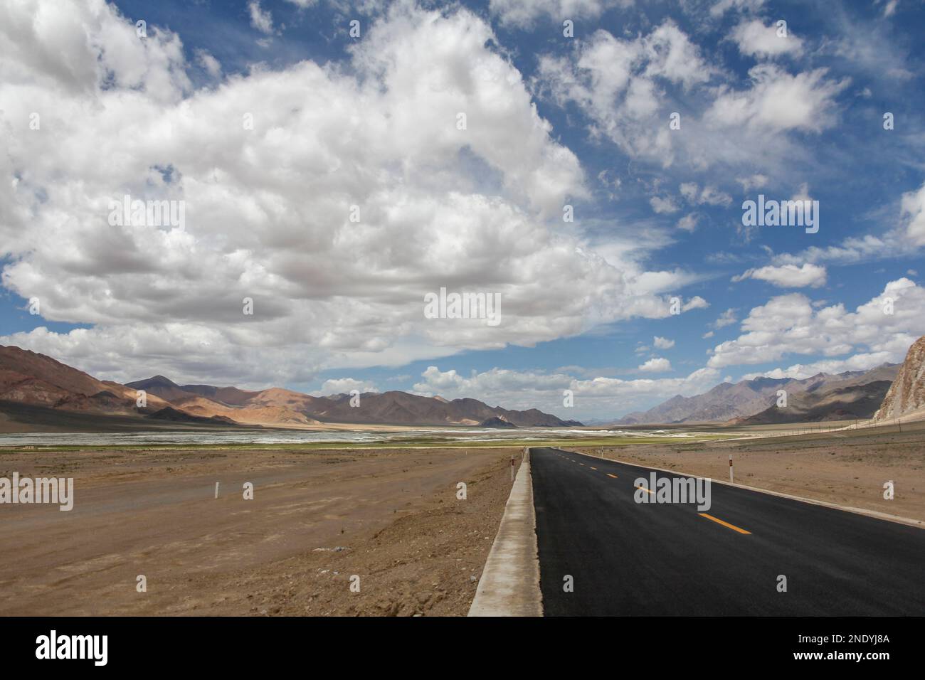 An aerial view of road through desert surrounded by hills Stock Photo ...