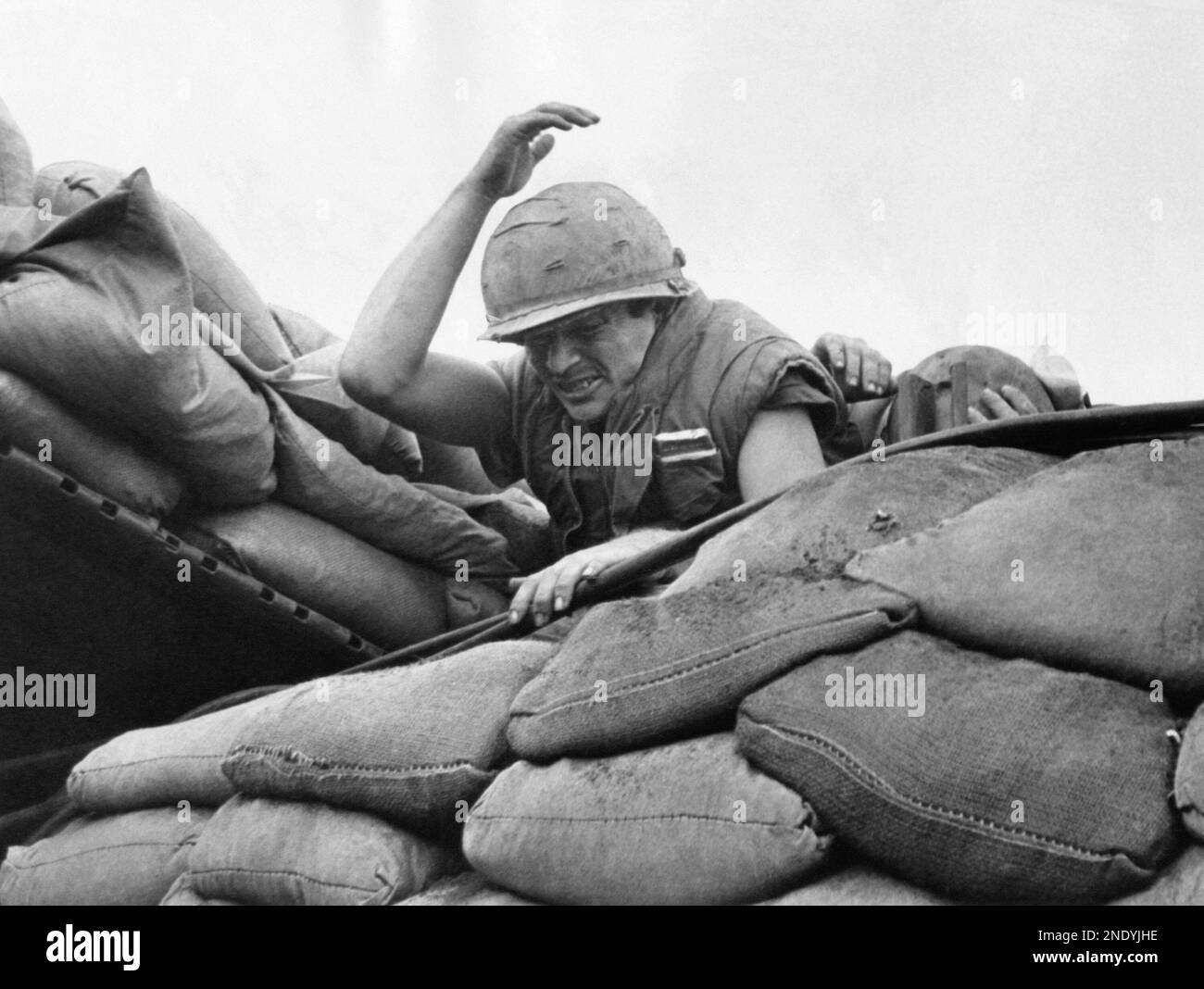 Marines take cover on the edge of their sandbagged bunker, unable to ...