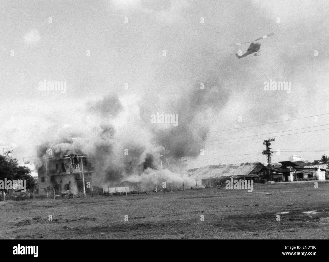 A U.S. Army helicopter gunship pulls up at right as the two rockets it ...