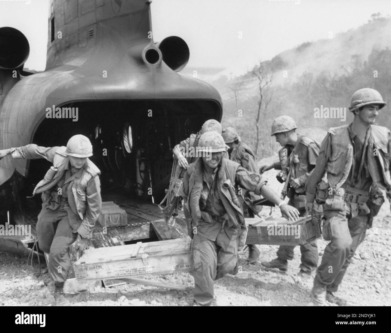 U.S. troops carry cases of artillery ammunition from a Chinook ...