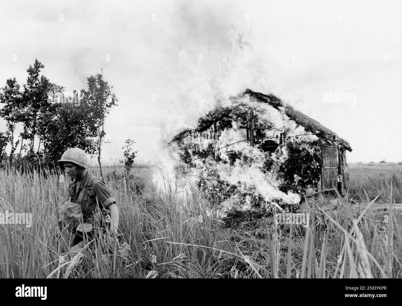 U.S. paratrooper moves away after setting fire to house on bank of the ...