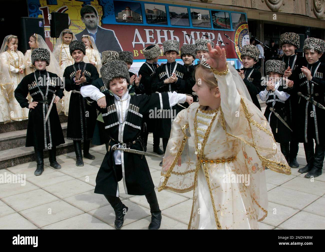 Chechen children dressed in traditional costumes dance during ...