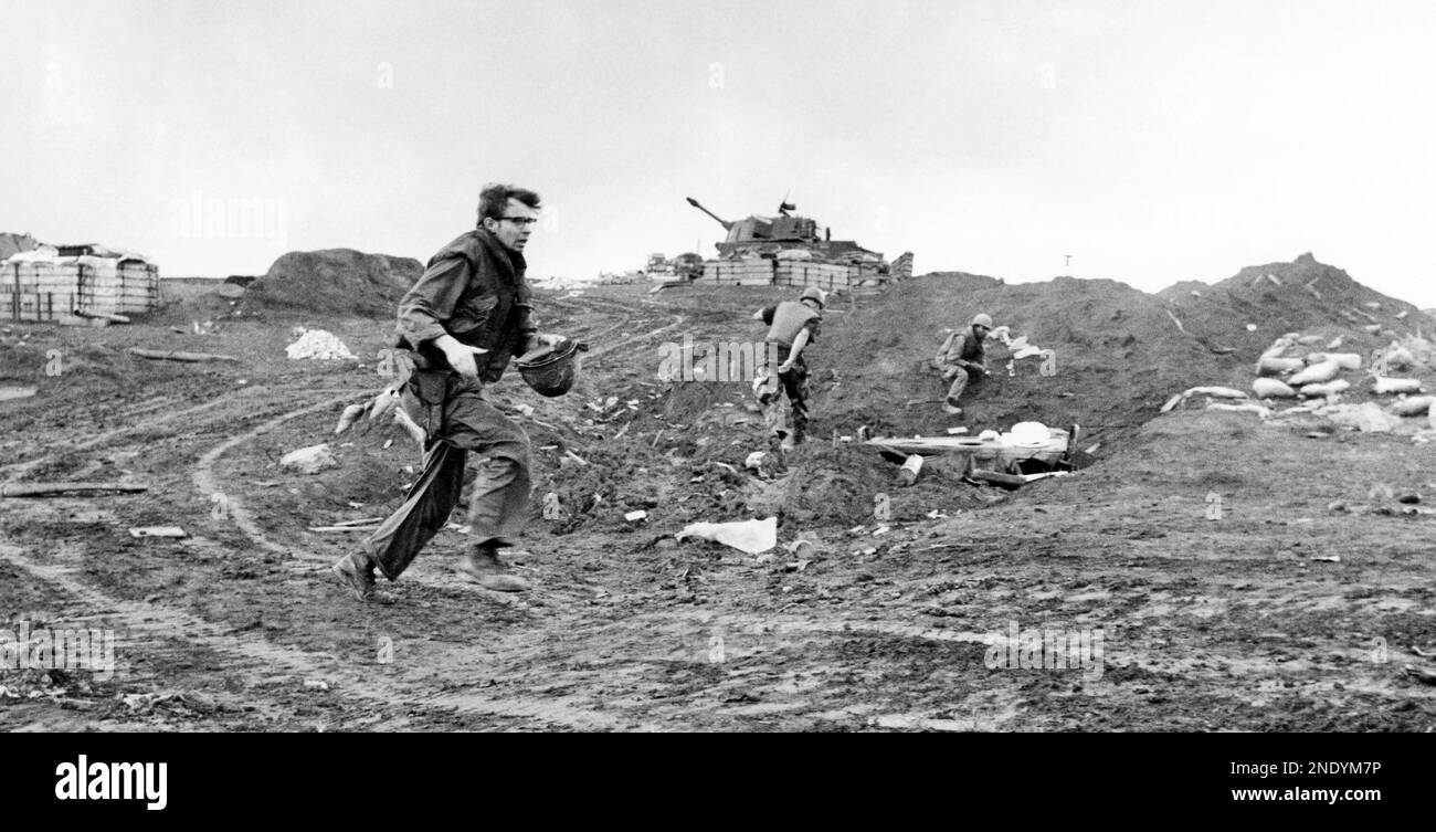 U.S. artillerymen run for cover as Viet Cong mortar and artillery ...