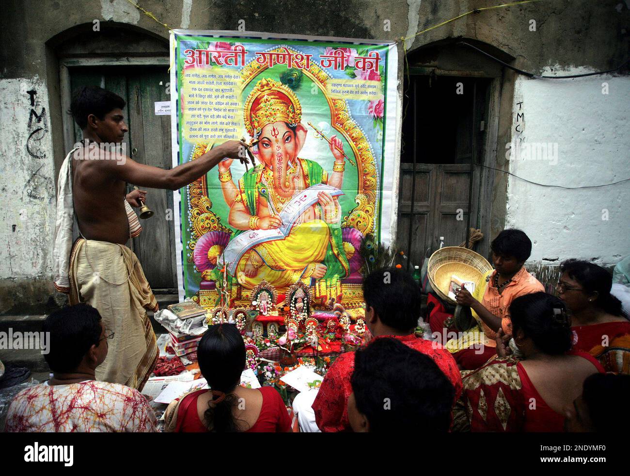 A Hindu priest performs rituals in front of a portrait of elephant ...