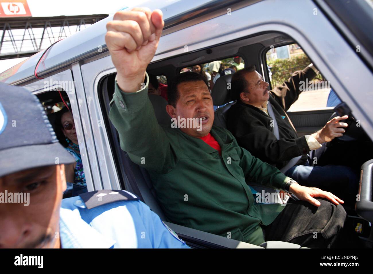 Venezuela's President Hugo Chavez, left, raises his fist inside a tryck ...