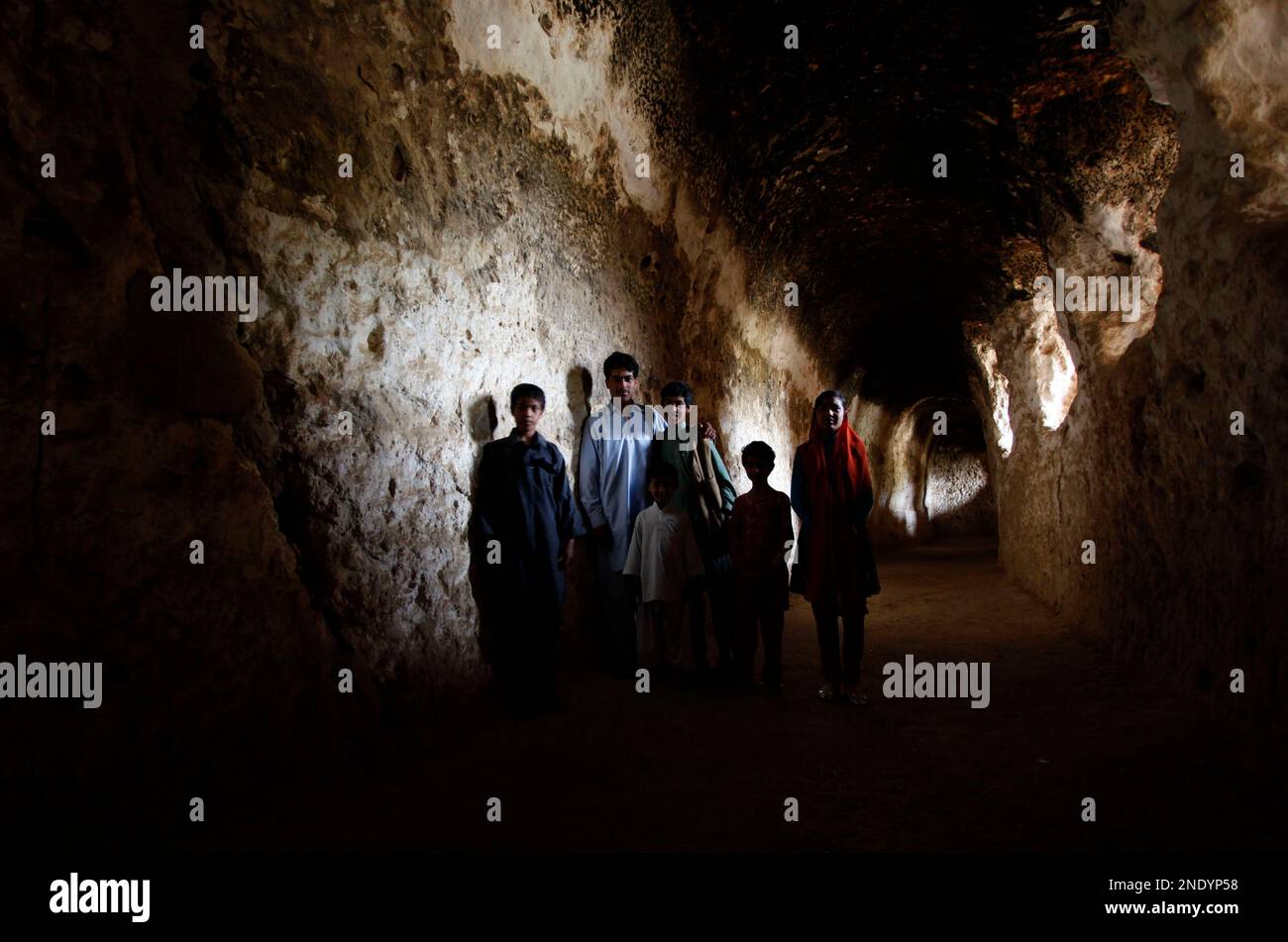 Afghan family poses for a picture inside the cave of Takht-e Rostam in ...