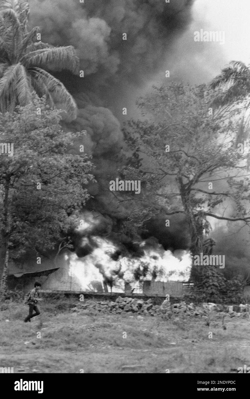 A Vietnamese boy flees past a blazing building in Hue on Feb. 11, 1968 ...