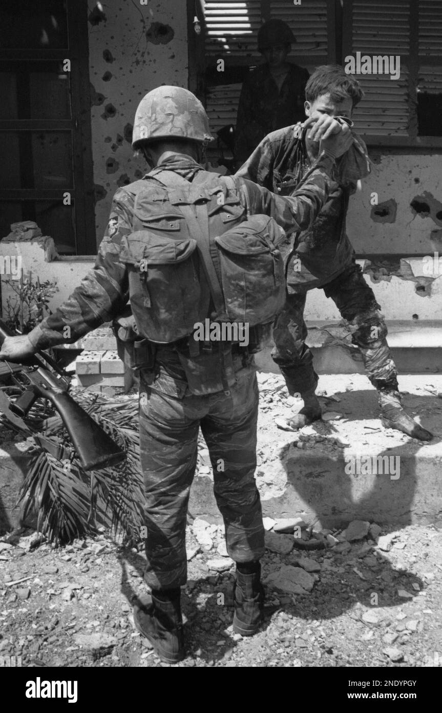 A South Vietnamese soldier, foreground, holds the wrist of a wounded ...