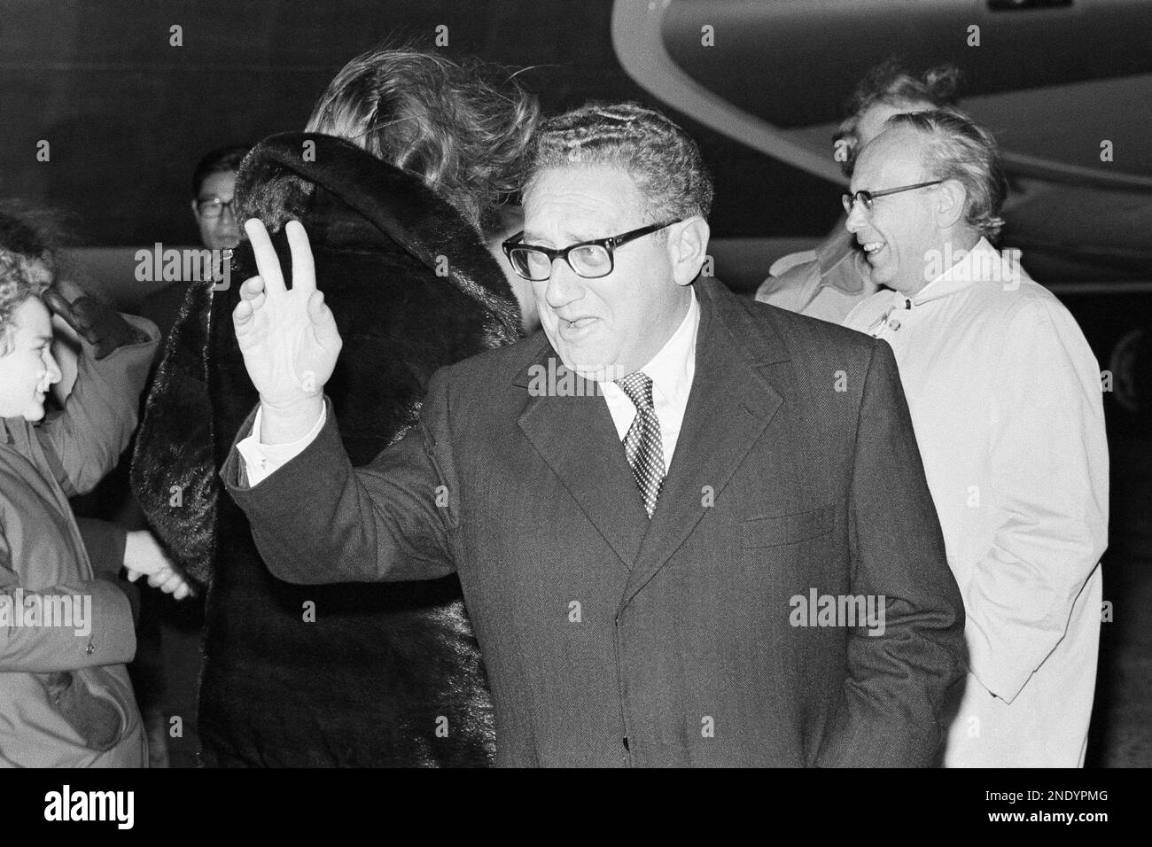 Secretary of State Henry Kissinger gives the "V" sign after landing at ...