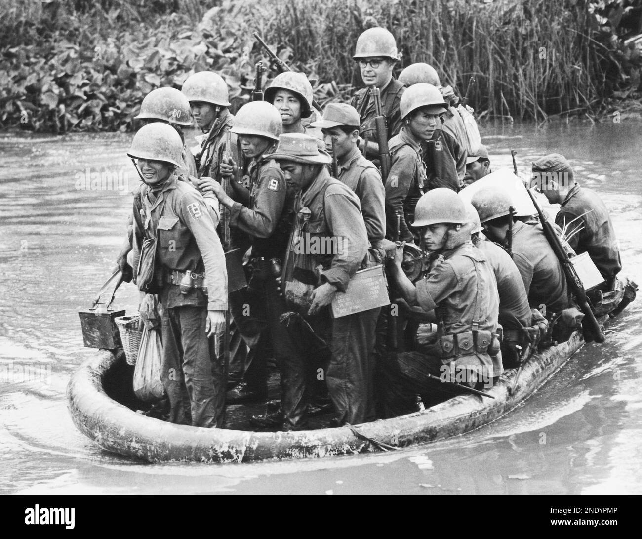 Vietnamese infantrymen and their American advisor crowd in a fiberglass ...