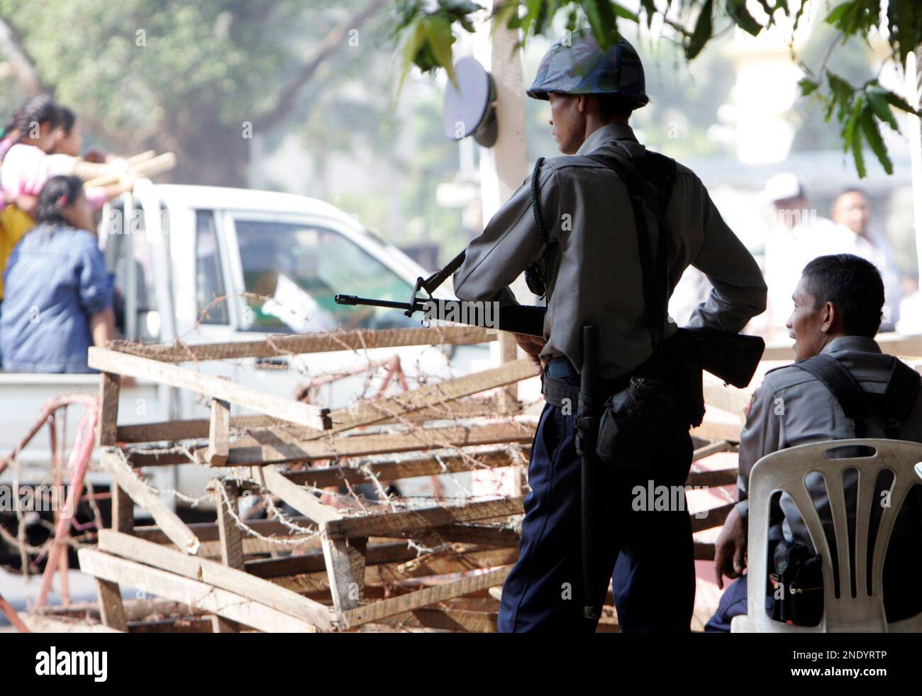 A security police stands guard as revelers ride cars during an annual ...
