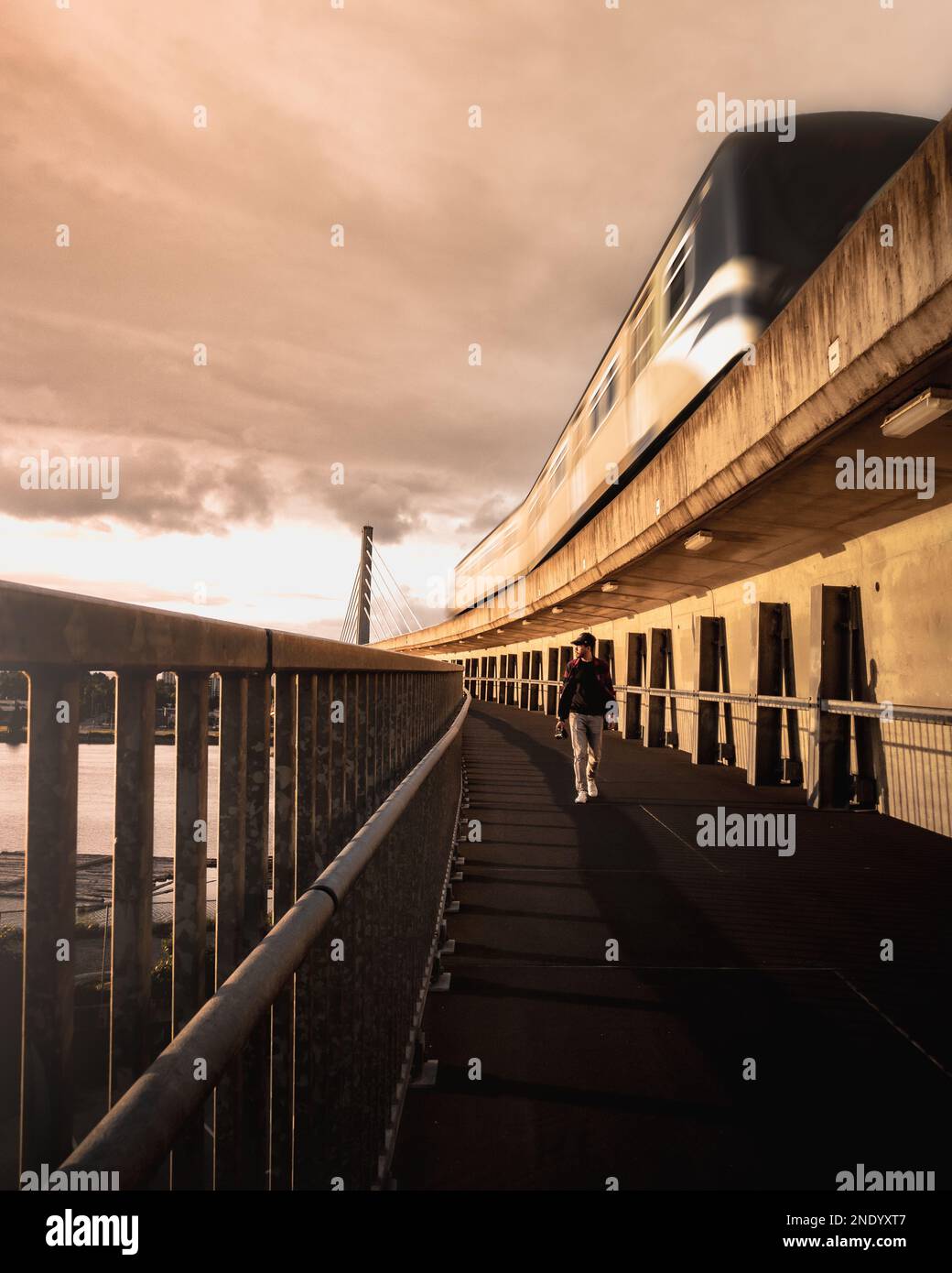 man walking on bridge as the skytrain passes Stock Photo - Alamy