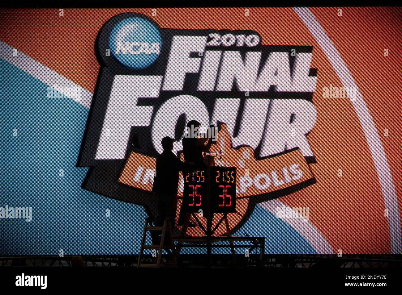 Workers are silhouetted by the NCAA Final Four logo while preparing for ...