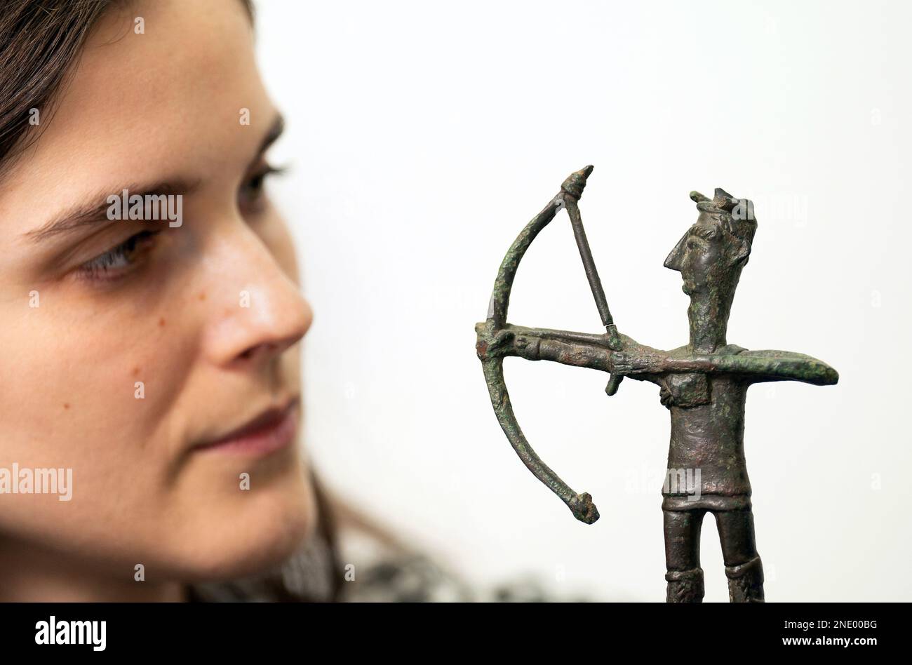 Olivia Maguire inspects a bronze figurine of an archer (1000???700 BCE ...