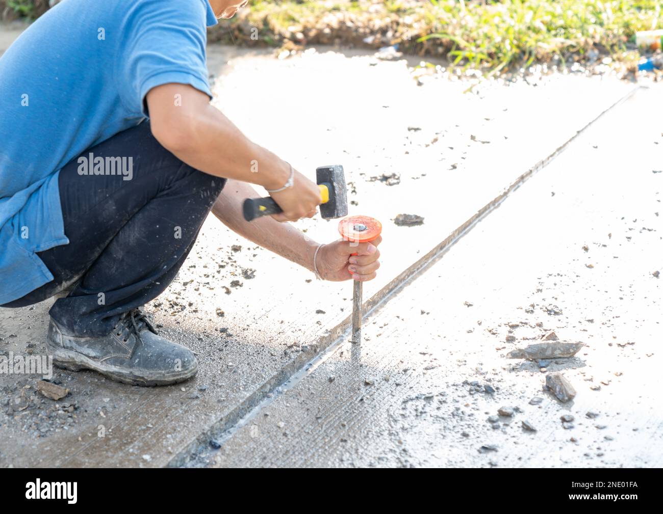 Worker with chisel and hammer hit the concrete for embeded pipe Stock ...