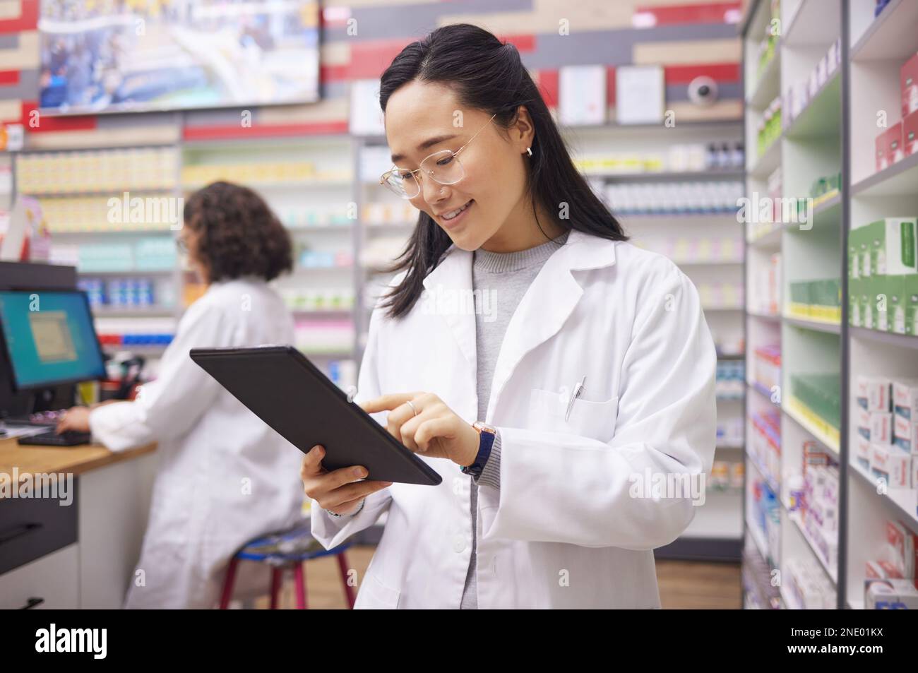 Pharmacy, tablet and asian pharmacist woman for medicine management, stock research and ...