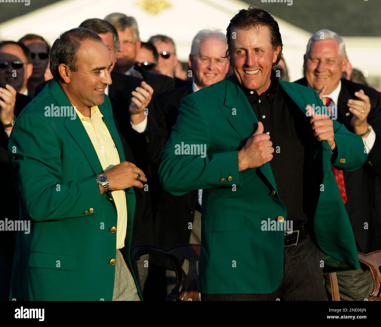 Former Master's champion Angel Cabrera, left, of Argentina helps Phil ...