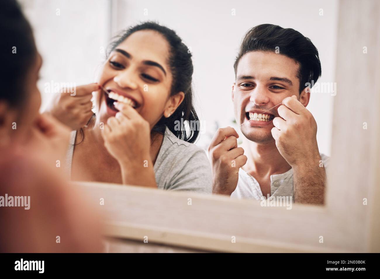 Our love shines as bright as our teeth. a young couple flossing their ...