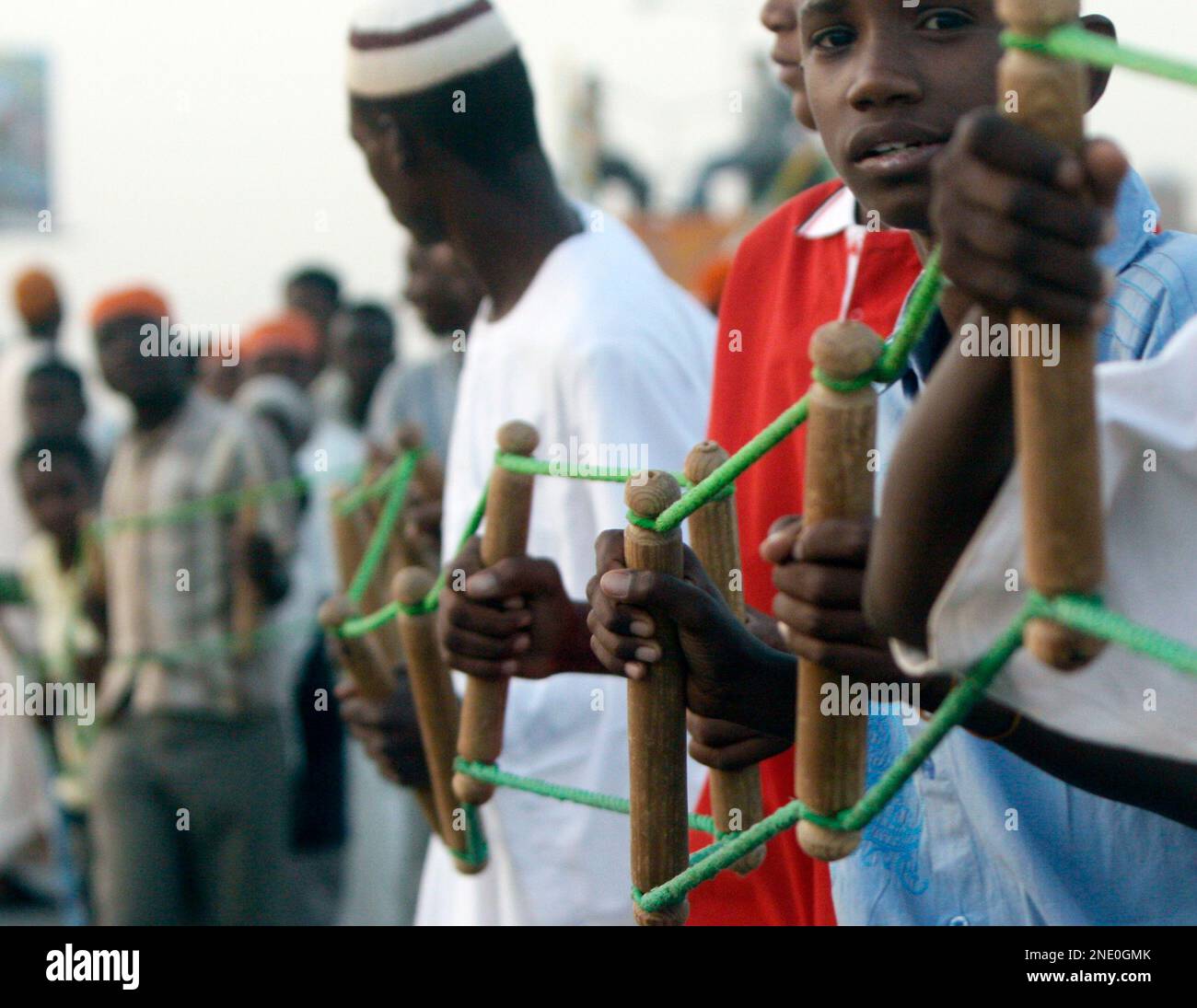 Sudanese Muslim boys use ropes to separate women and men during a ...